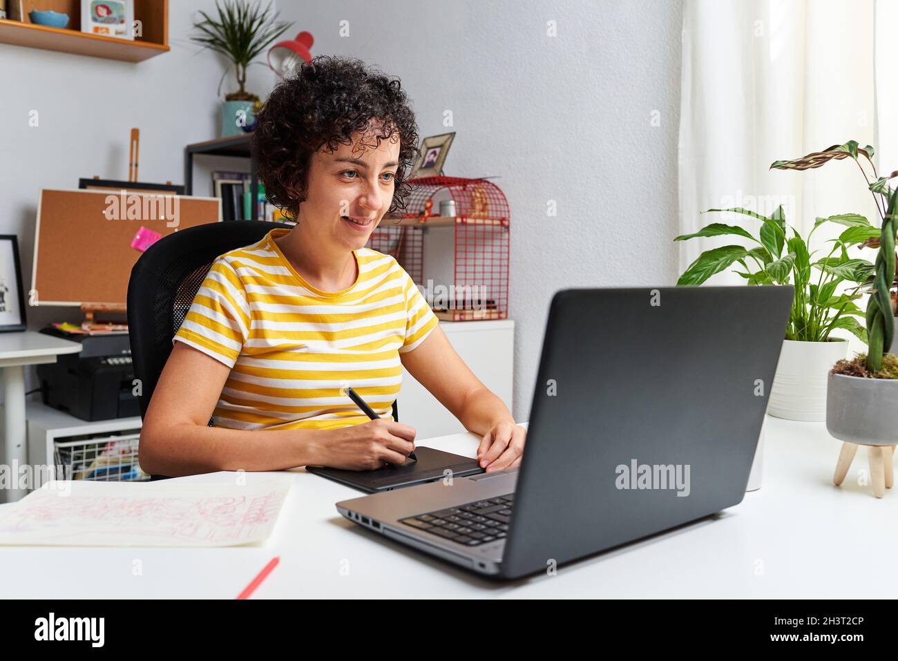 Graphic designer working from home with a graphic tablet and laptop ...