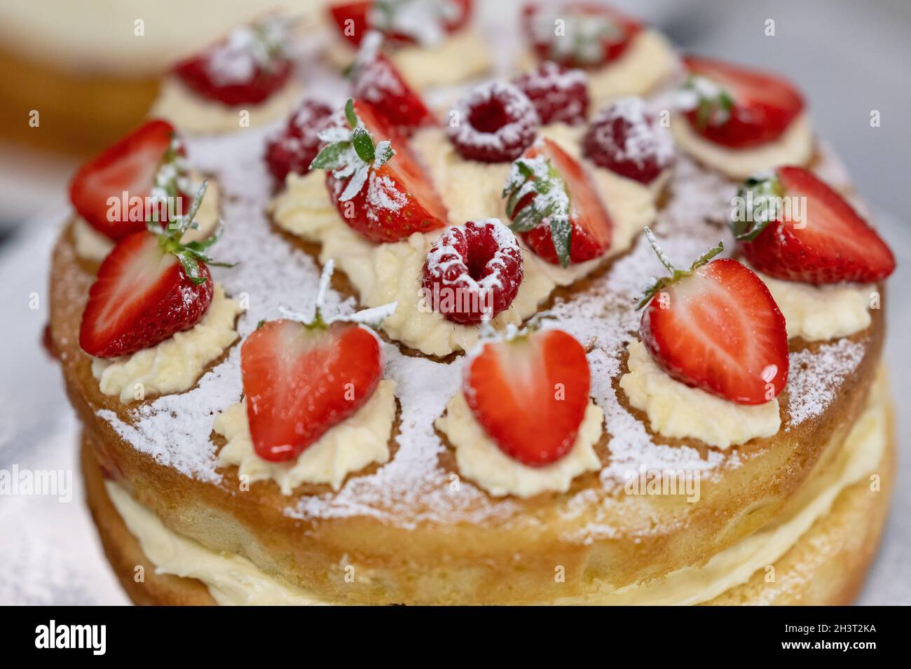 A Victoria sponge cake covered in strawberries Stock Photo - Alamy