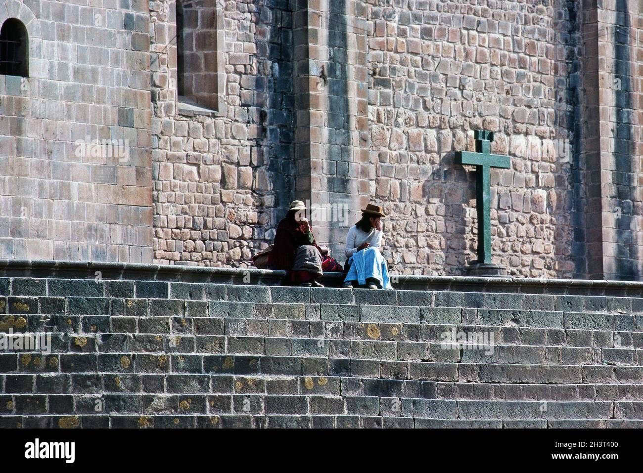 People sitting on steps by church in Cuzco Stock Photo - Alamy