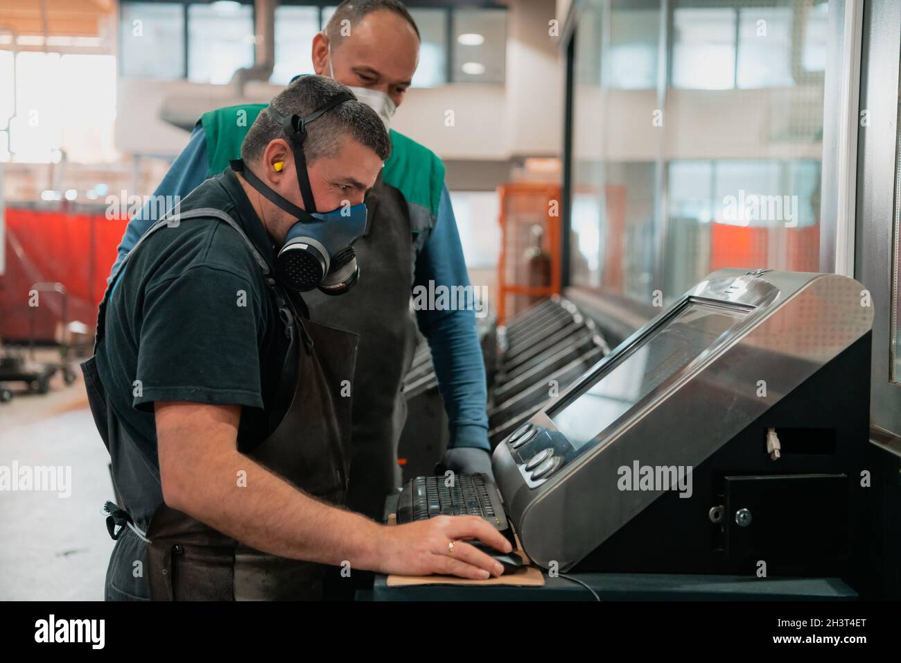 Two workers wearing a face mask due to a coronavirus pandemic are ...