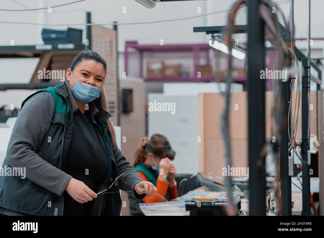 An obese woman works in a heavy metal factory, wearing a mask on her ...