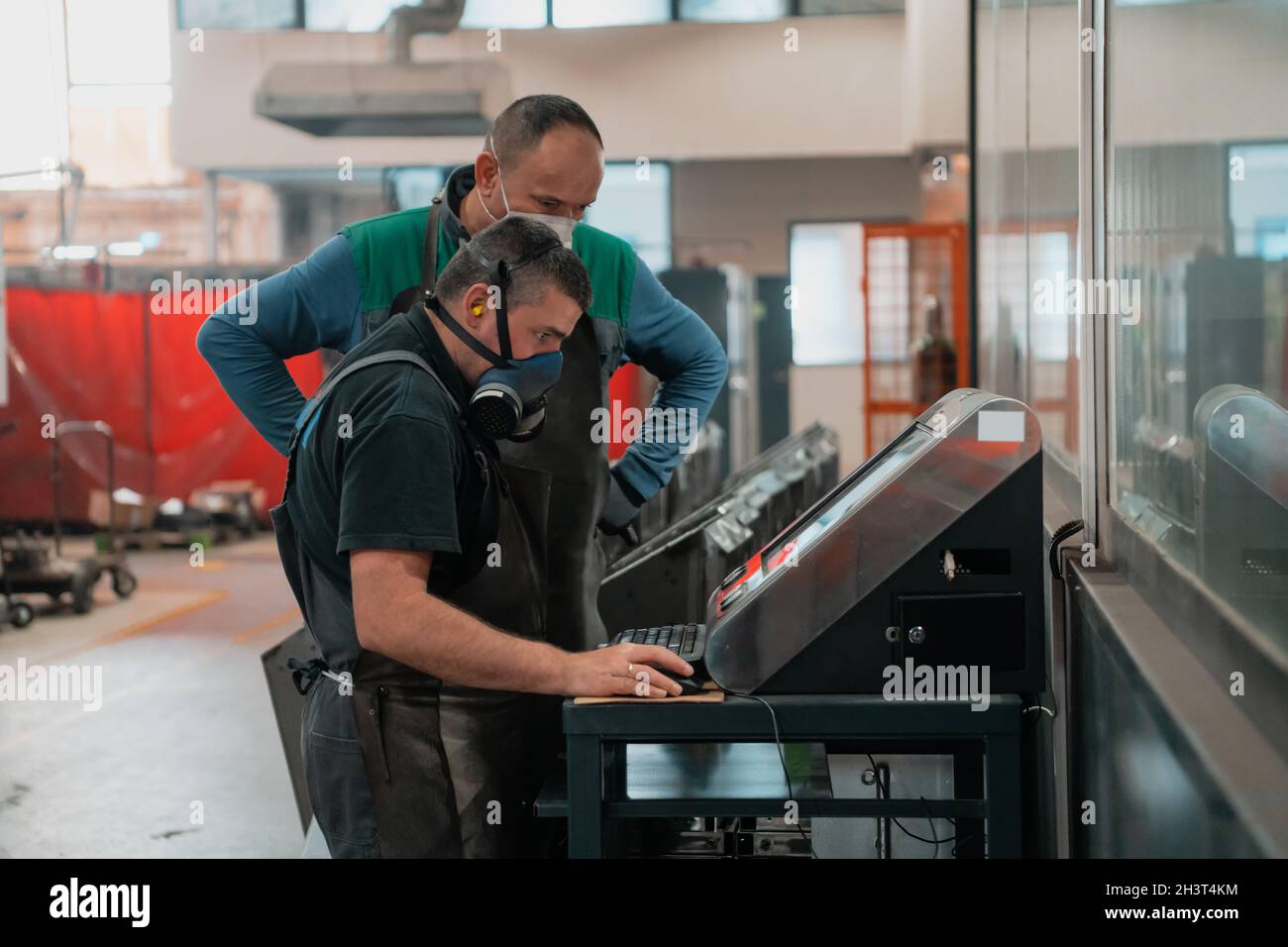 Cnc machine and workers with mask hi-res stock photography and images ...