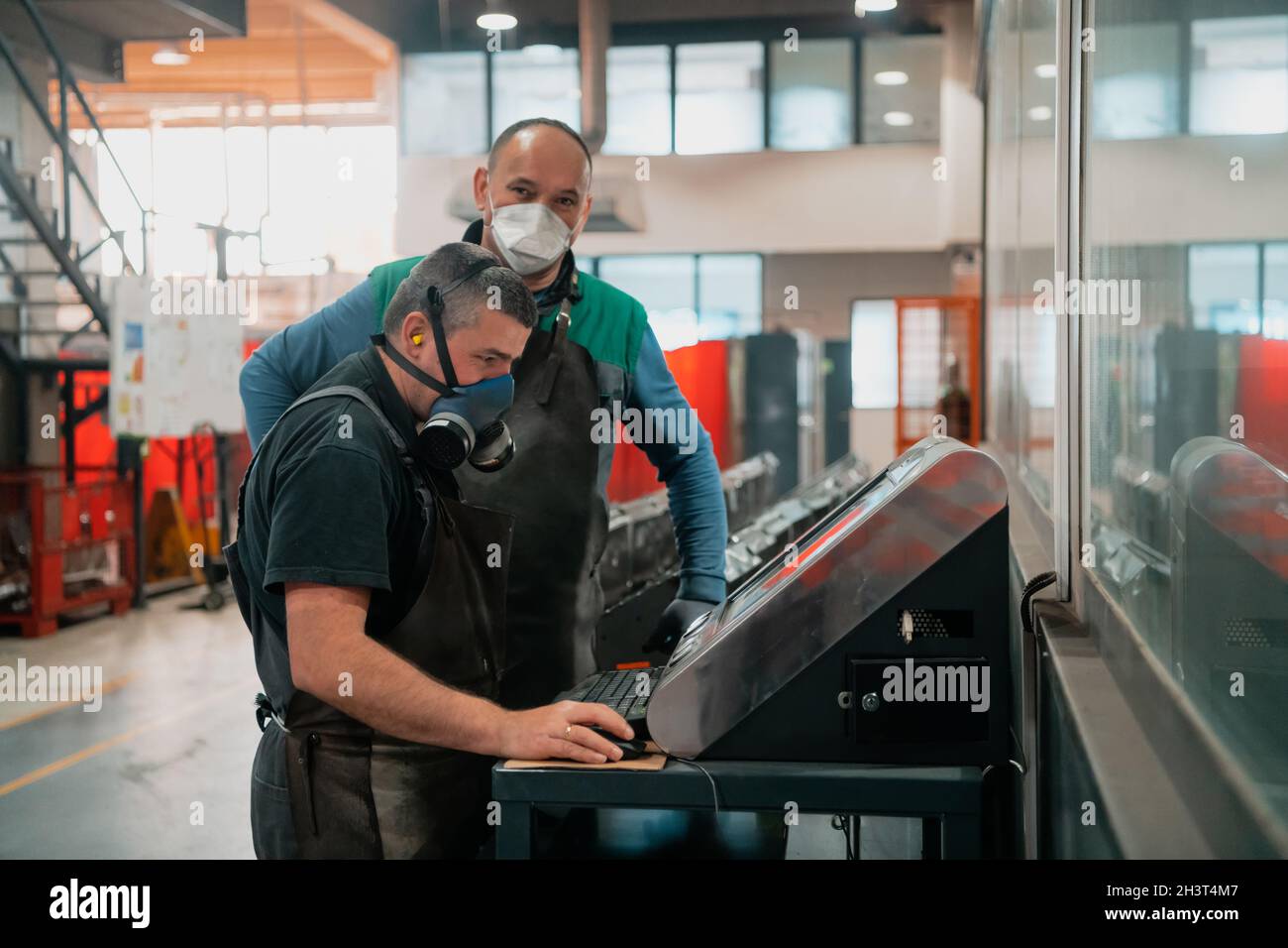 Two workers wearing a face mask due to a coronavirus pandemic are ...