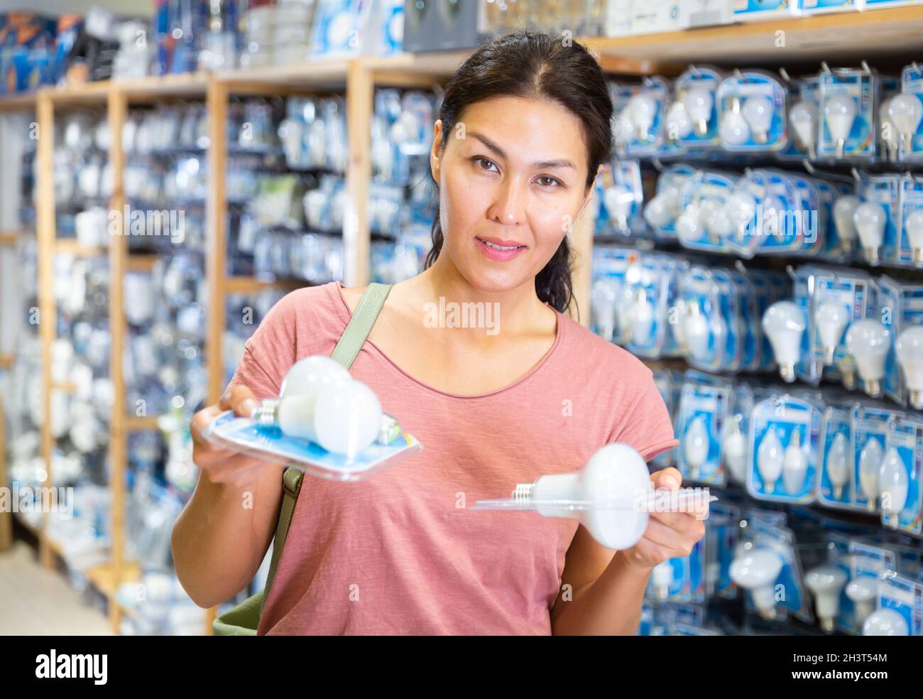 Asian female selecting energy efficient light bulbs Stock Photo - Alamy