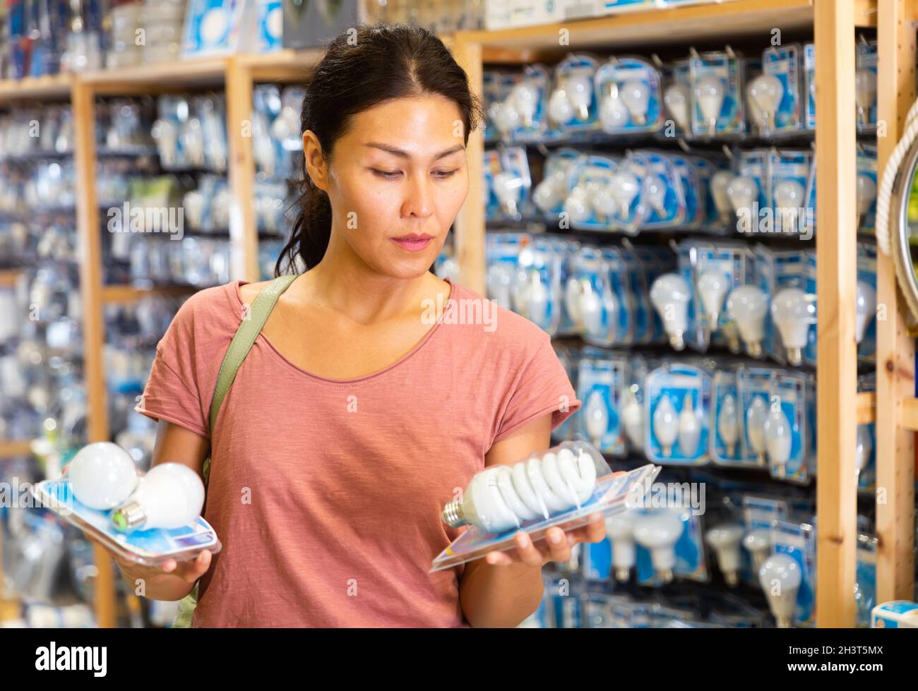 Asian female selecting energy efficient light bulbs Stock Photo - Alamy