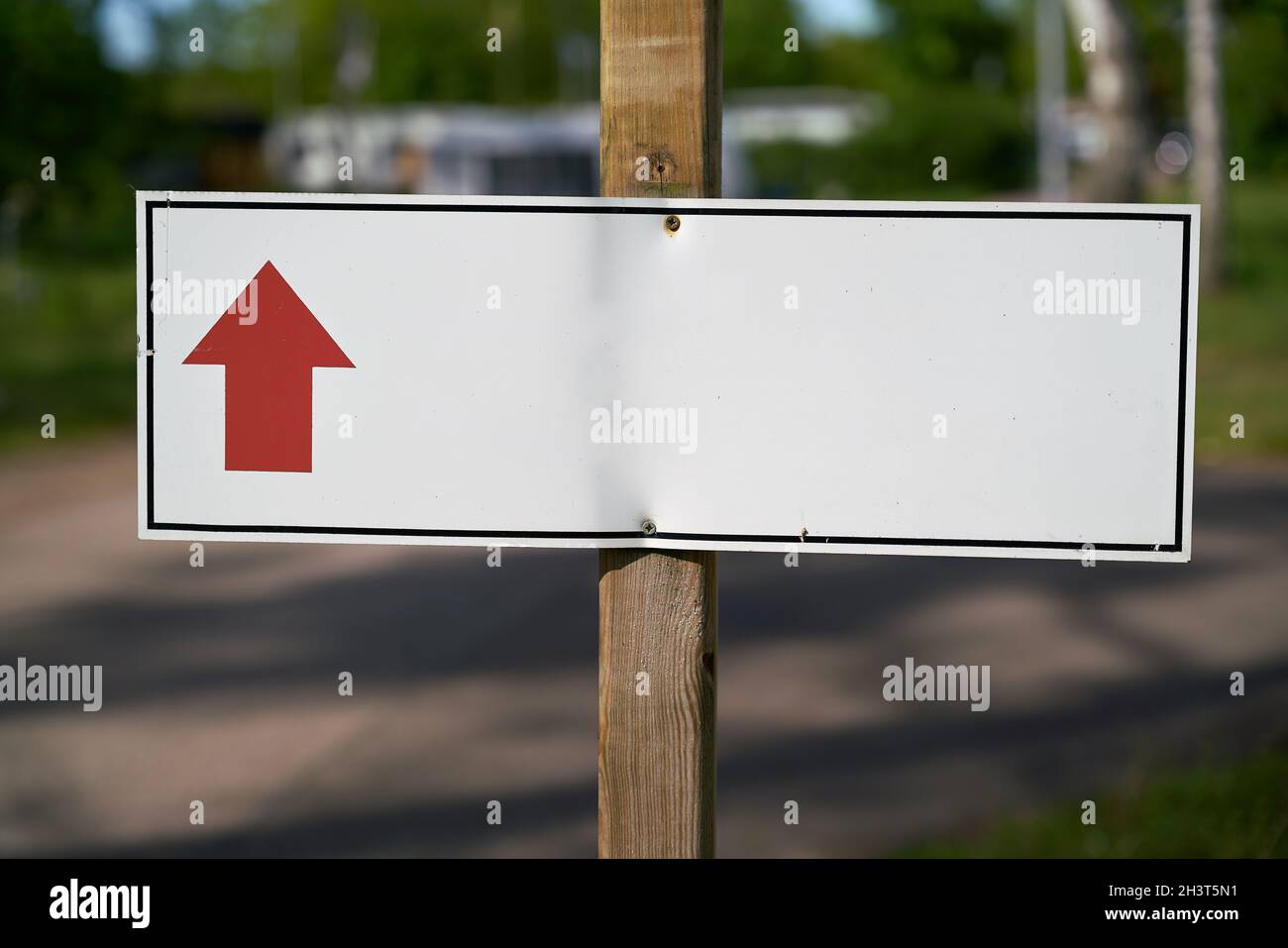 Signpost with directional arrow on a path at a campsite Stock Photo - Alamy