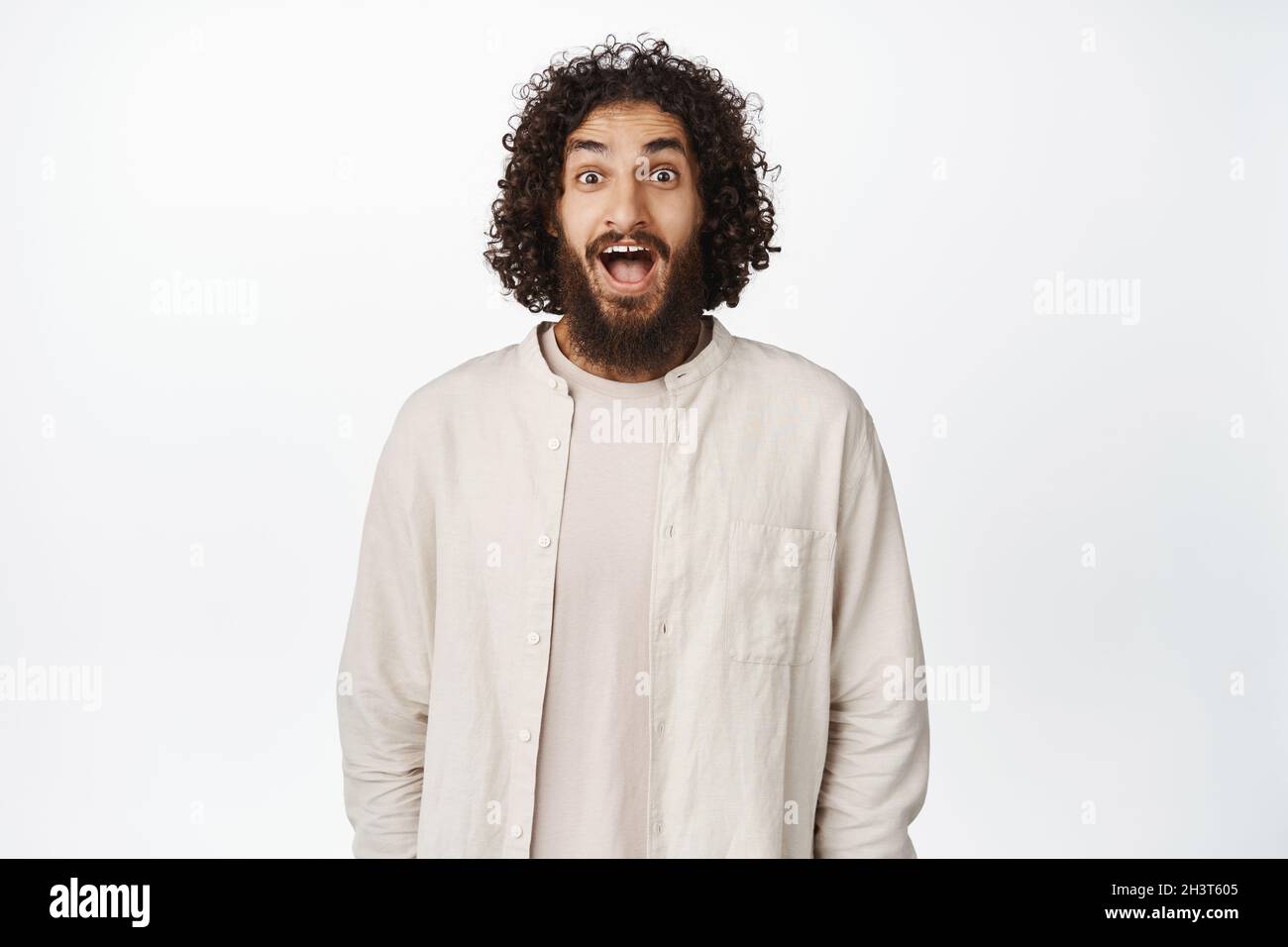 Portrait of surprised and excited middle eastern man, drop jaw and ...