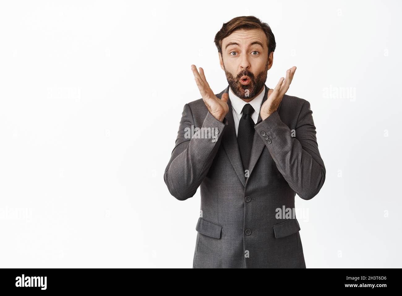 Surprised corporate guy looking amazed and happy at camera, say wow ...