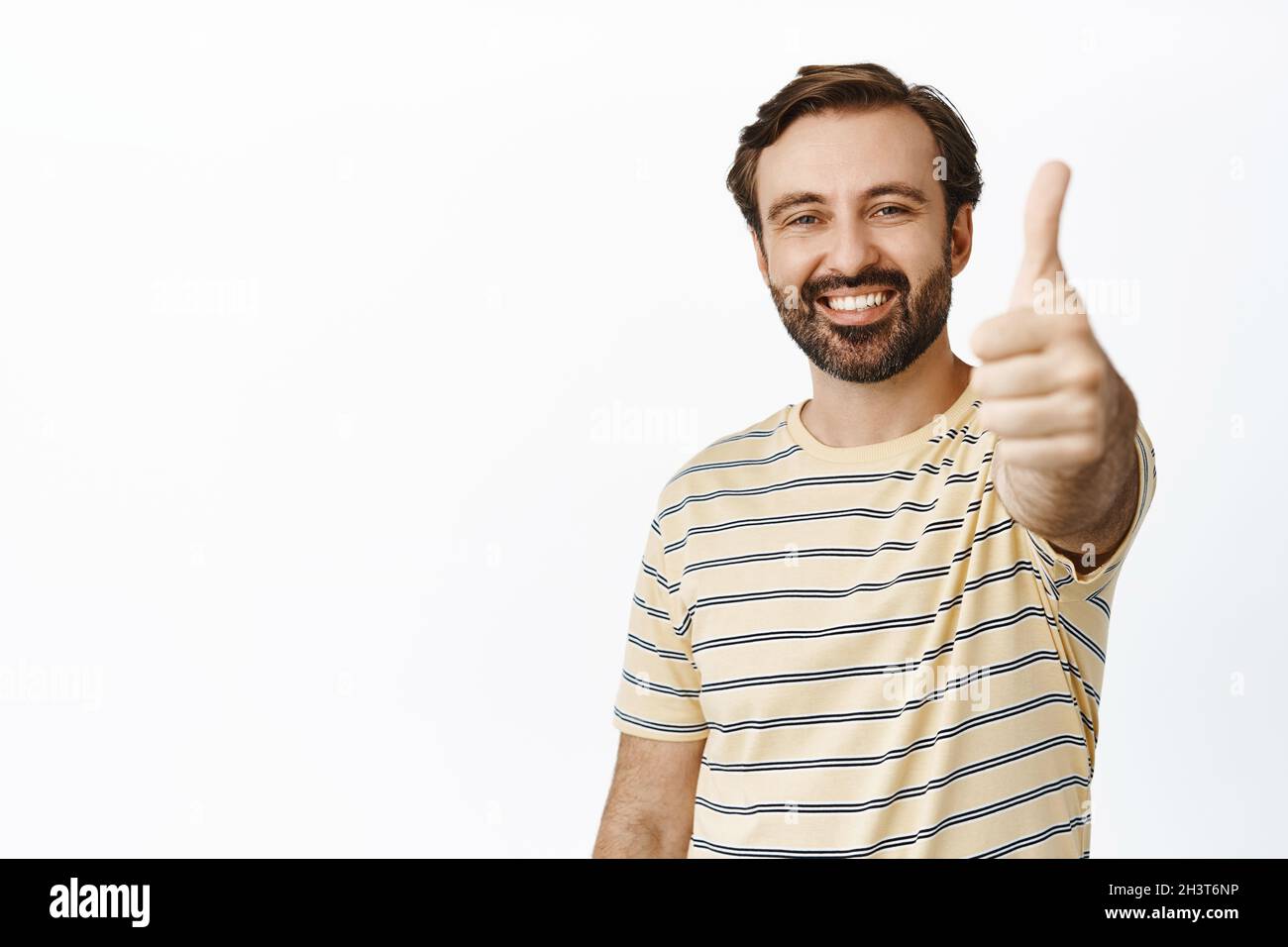 Very good. Smiling pleased bearded man extends hand with thumbs up ...