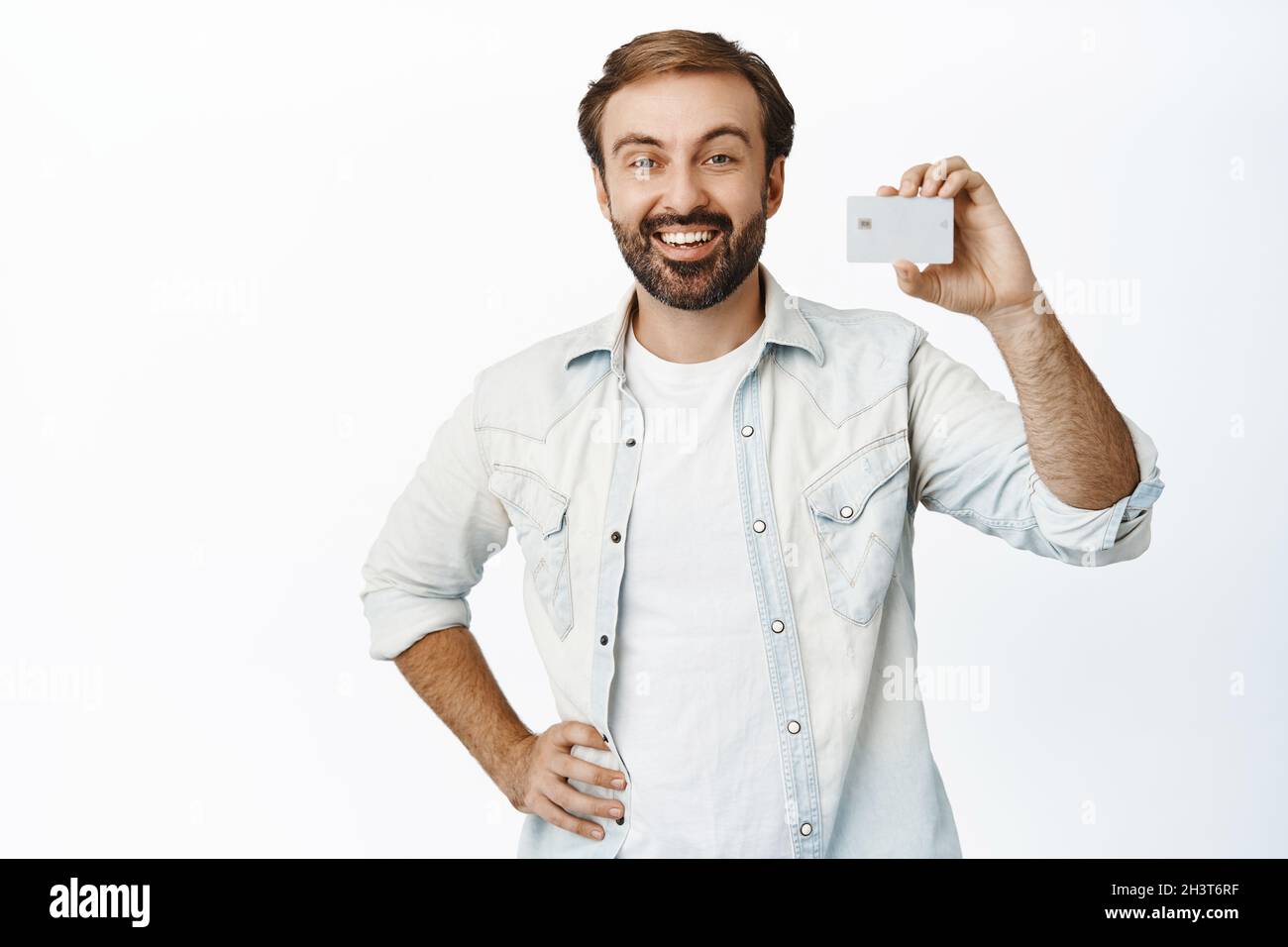 Handsome modern man with beard, showing credit card and smiling ...