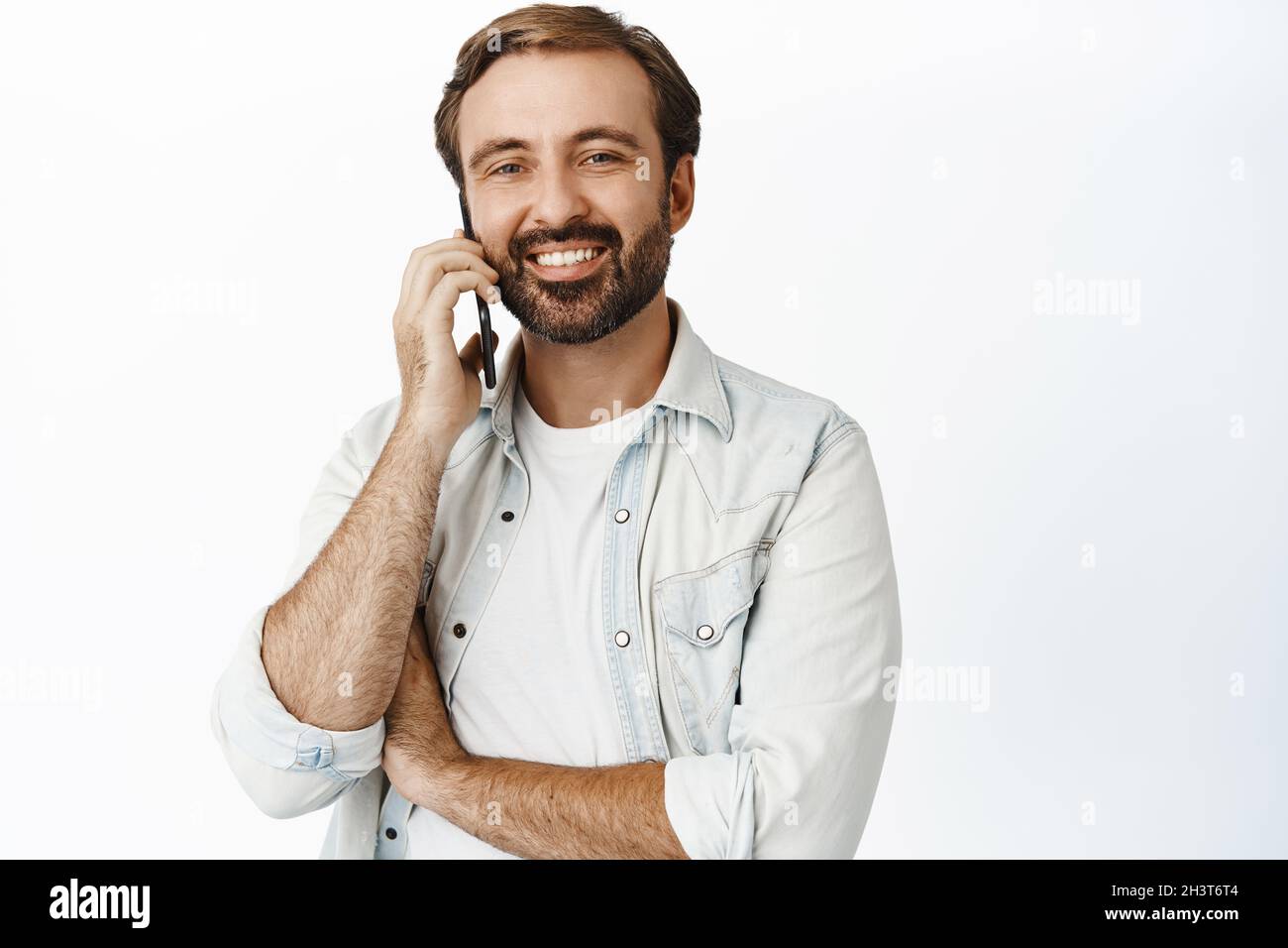 Smiling man having phone call, talking on smartphone and looking happy ...