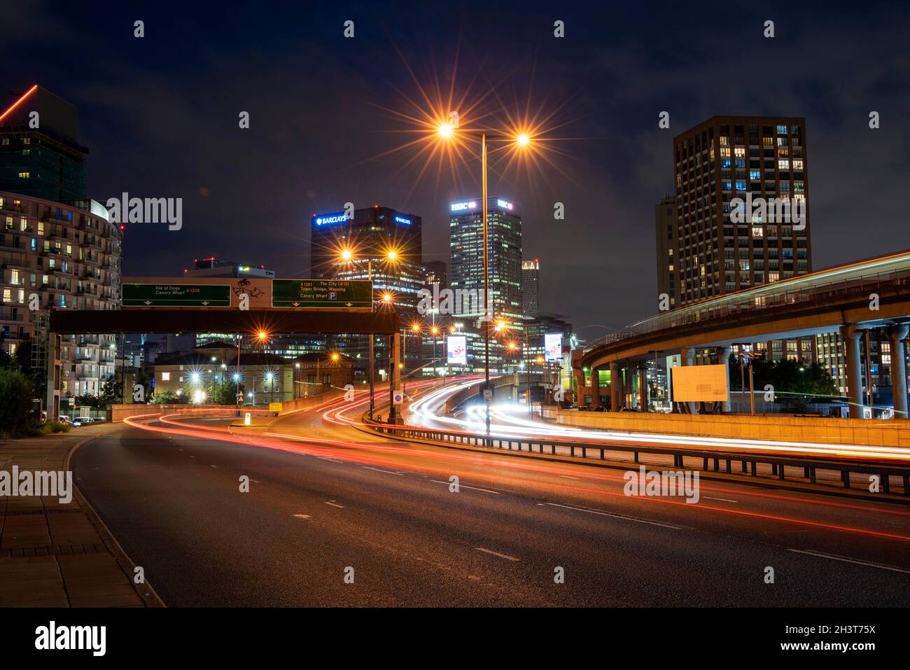 Traffic light trails on Aspen Way looking towards Canary Wharf, London ...