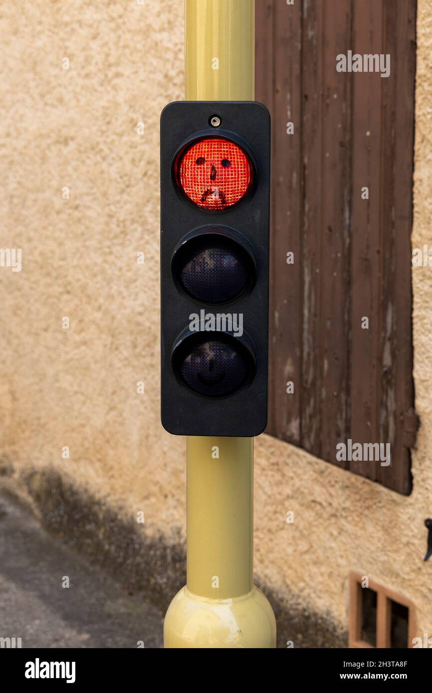 French comic paints a sad face on the red stop sign of the traffic ...