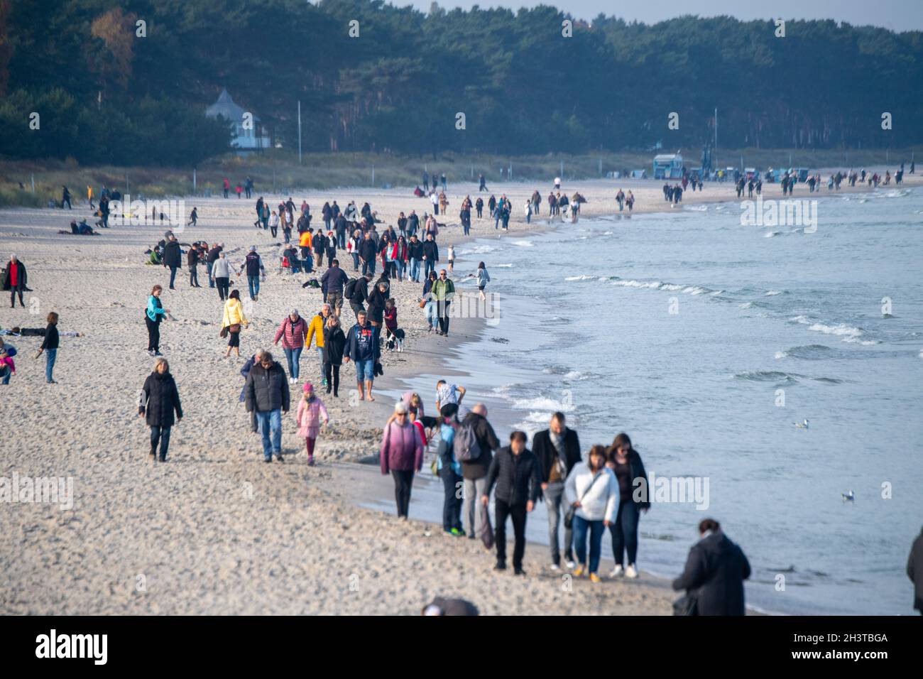 Binz, Germany. 30th Oct, 2021. Tourists walk along the beach in front ...