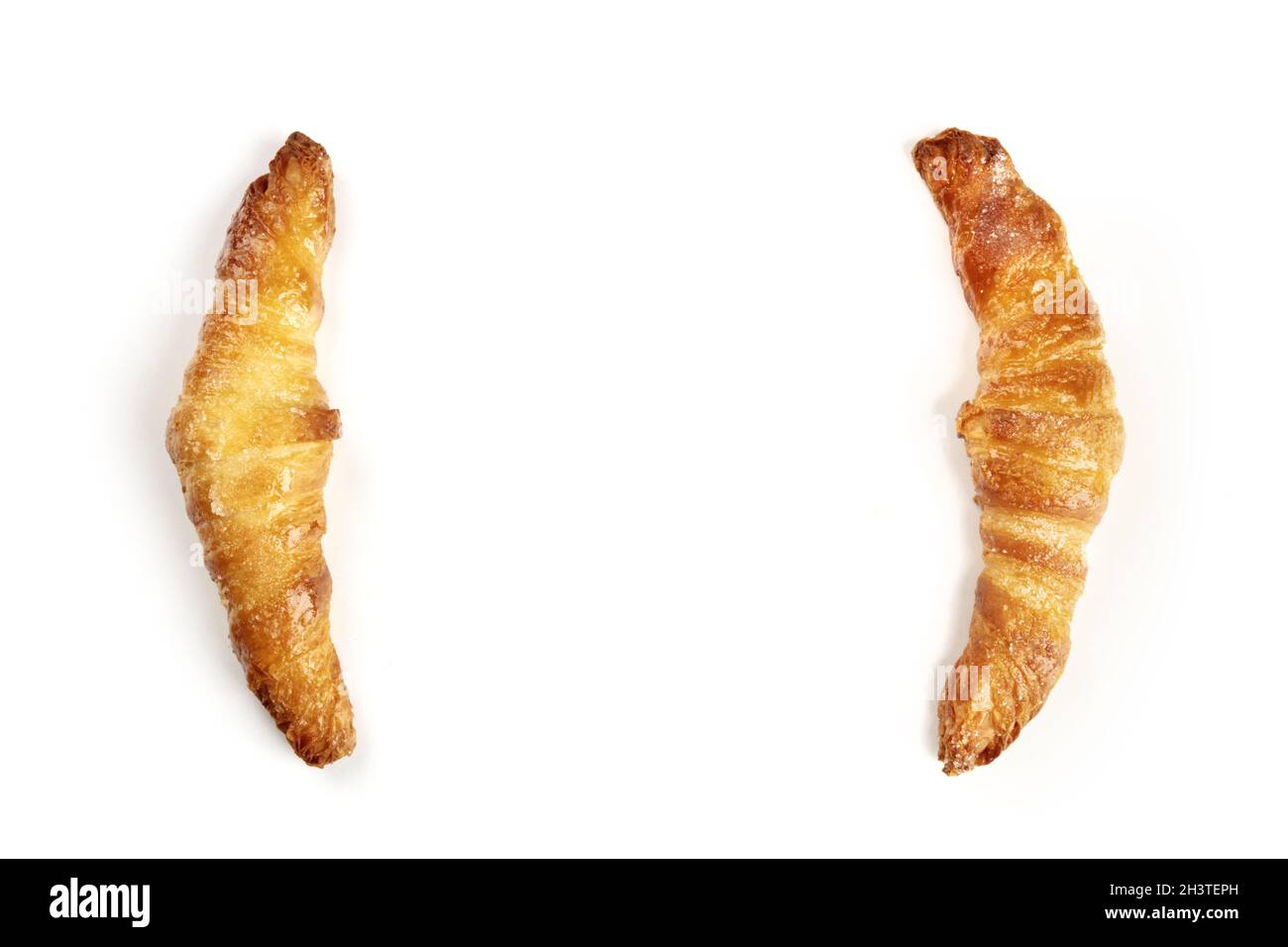Two croissants on a white background, shot from the top, forming a ...