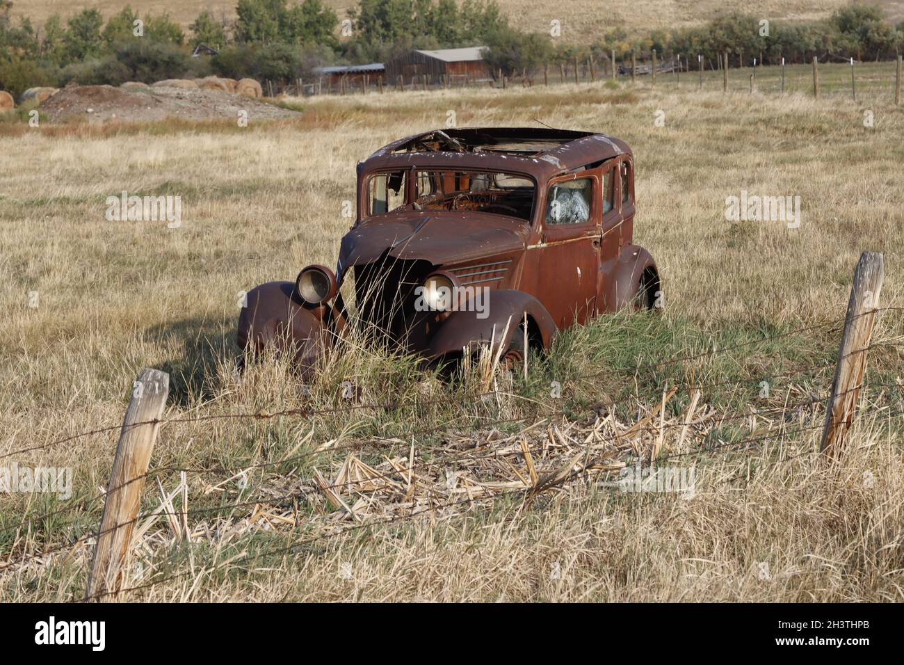 A vintage car in a farmer's field as a reminder of things past Stock ...