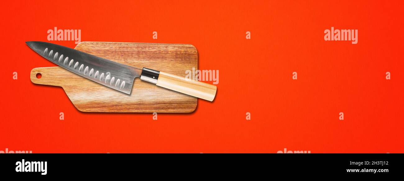 Traditional Japanese gyuto chief knife on a cutting board. Red banner ...
