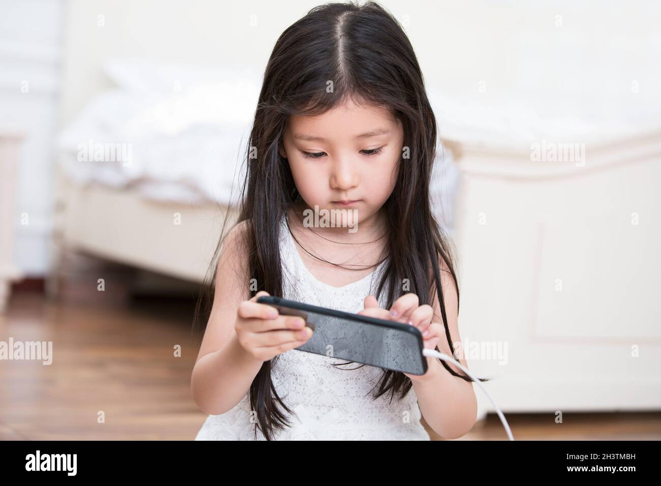 Little girl playing with her cell phone Stock Photo - Alamy