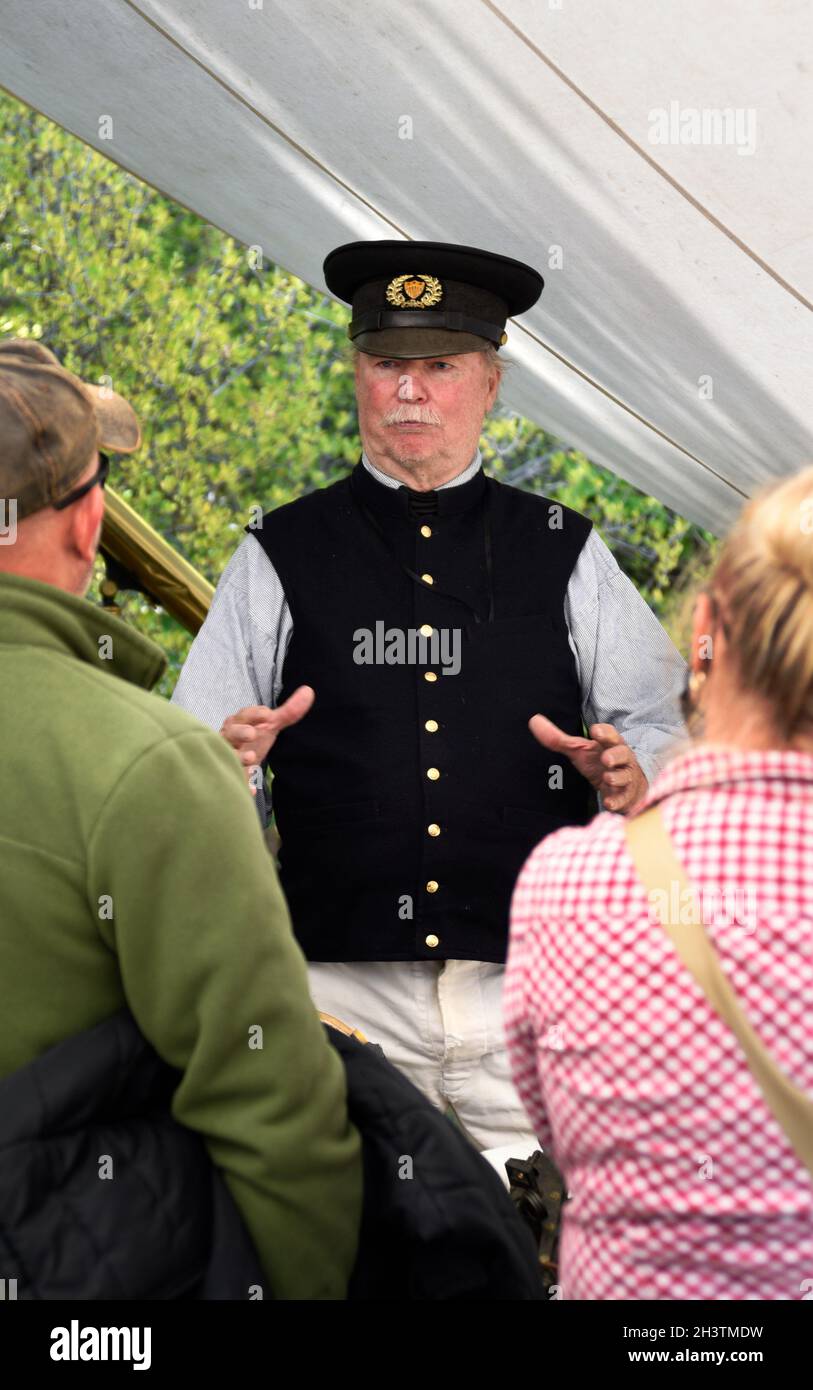 A reenactor dressed as a 19th century U.S. Dragoon soldier talks to ...