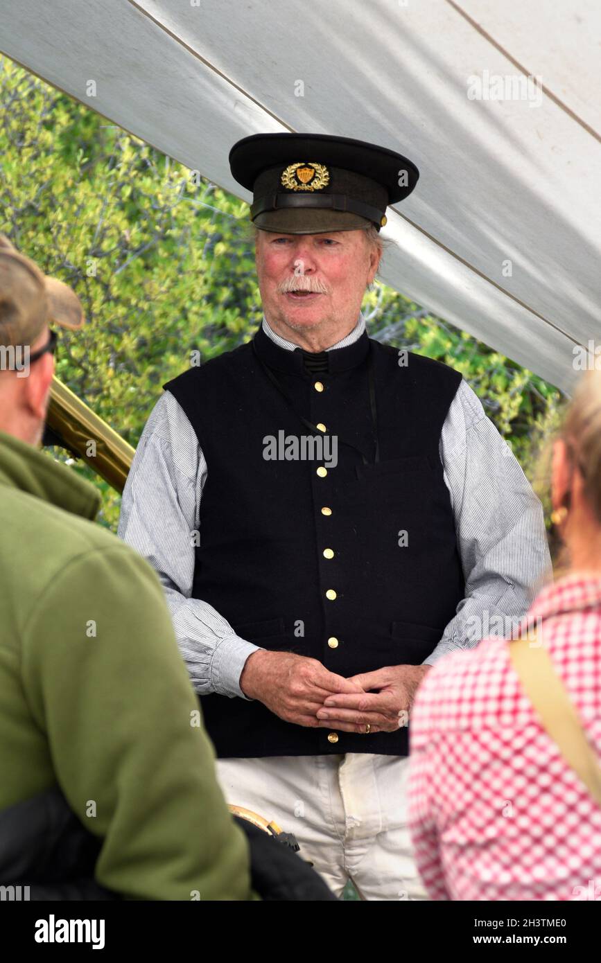 A reenactor dressed as a 19th century U.S. Dragoon soldier talks to ...