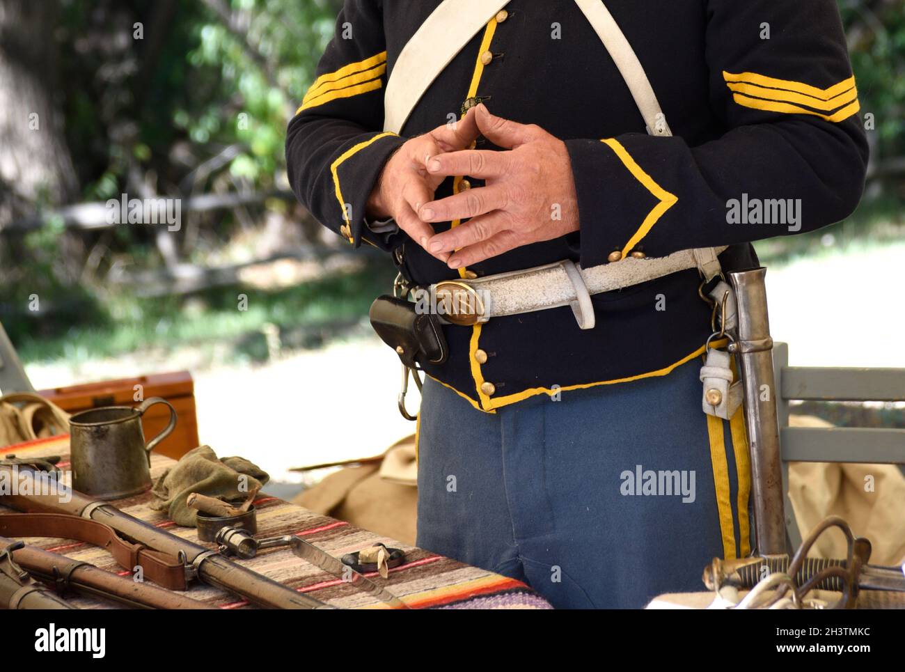 A reenactor dressed as a 19th century U.S. Dragoon soldier talks to ...