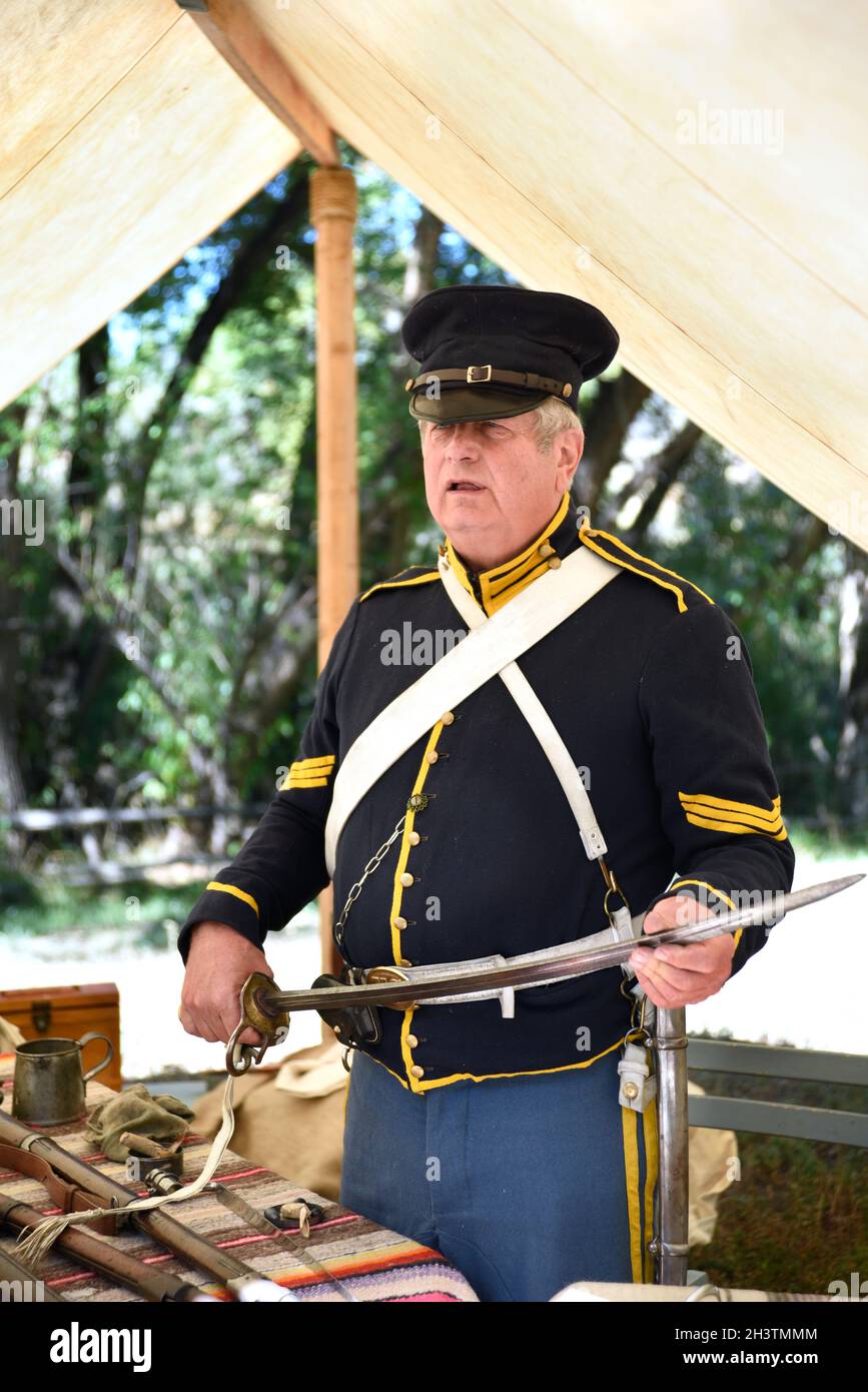 A reenactor dressed as a 19th century U.S. Dragoon soldier talks to ...