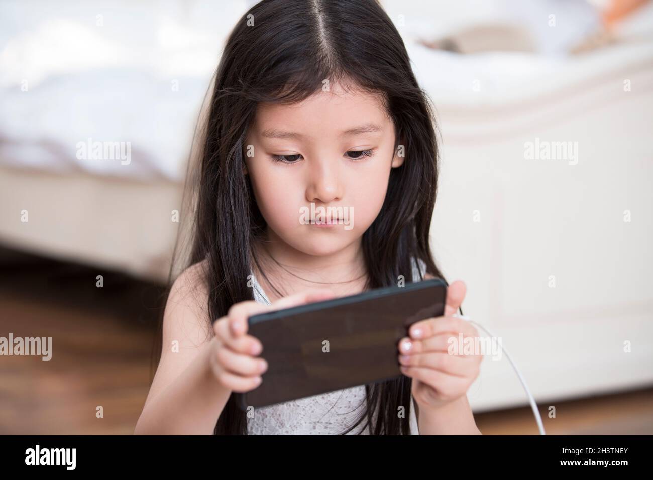 Little girl playing with her cell phone Stock Photo - Alamy