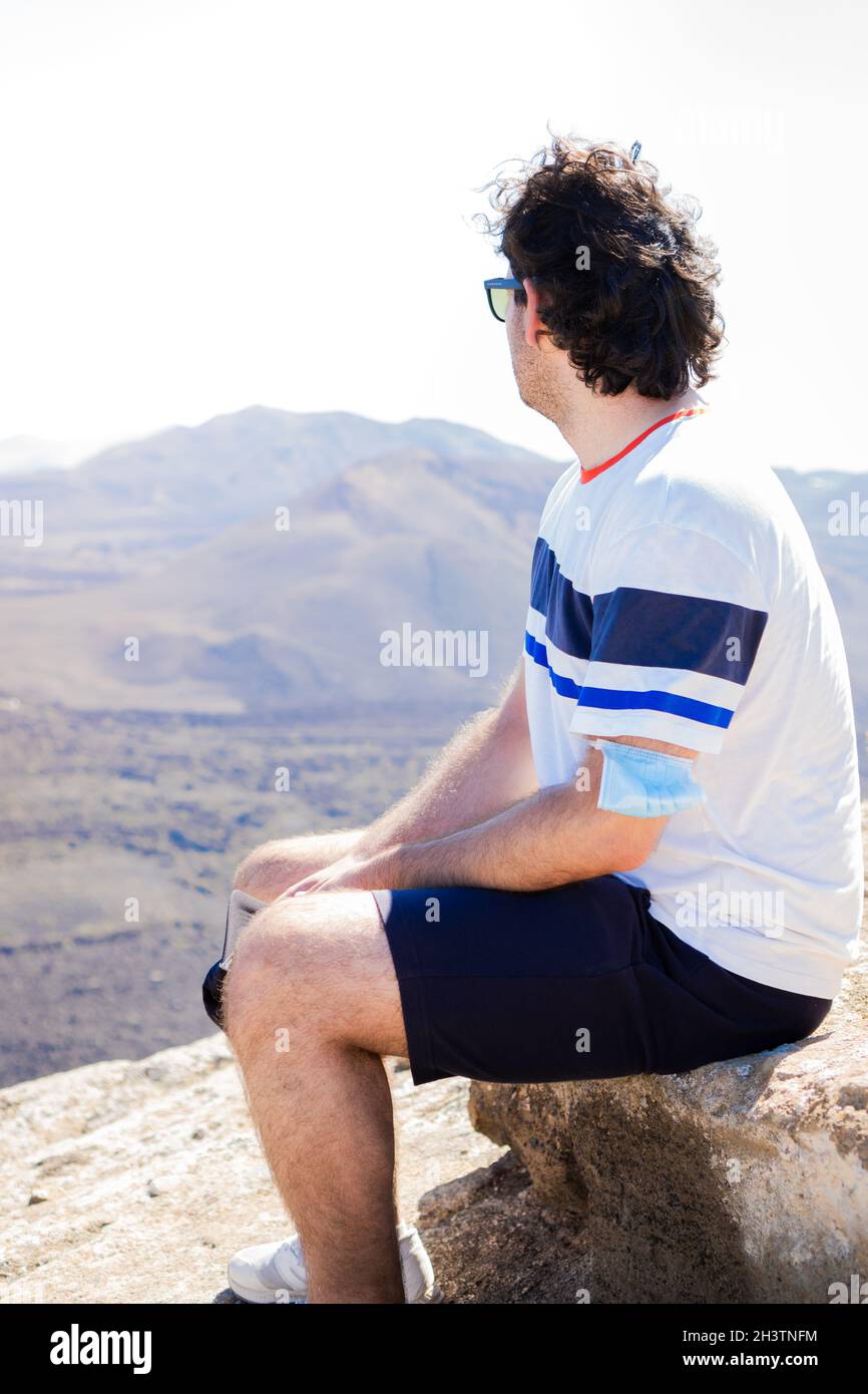 Traveler resting on the top of a mountain while looking the scenery ...