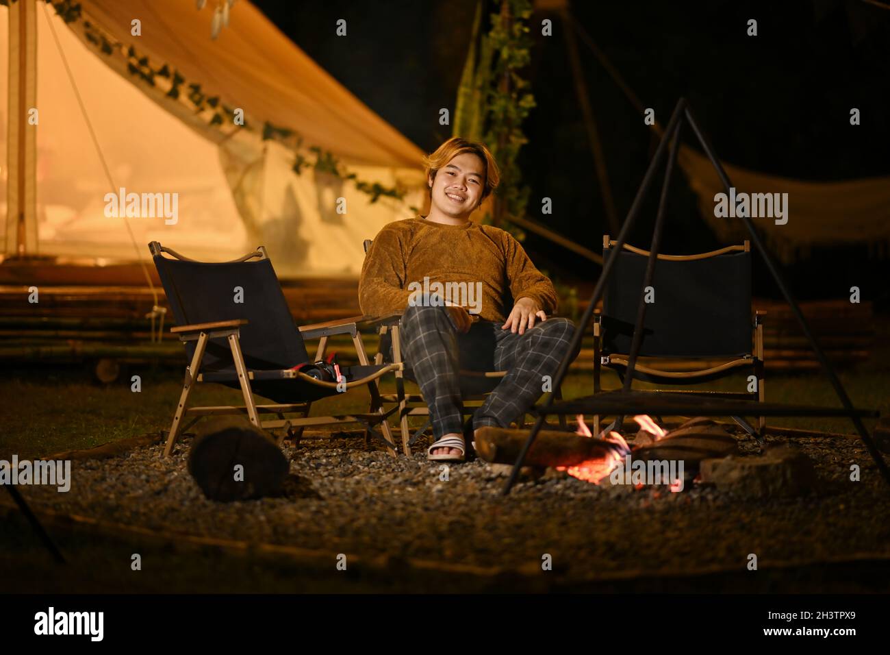 Happy man sitting near bonfire hi-res stock photography and images - Alamy