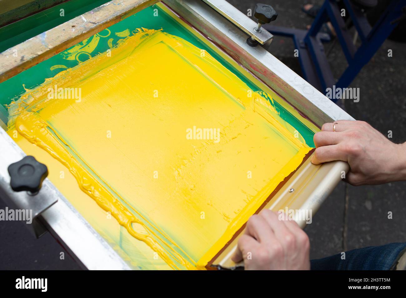Serigraphy silk screen print process at clothes factory. Frame ...