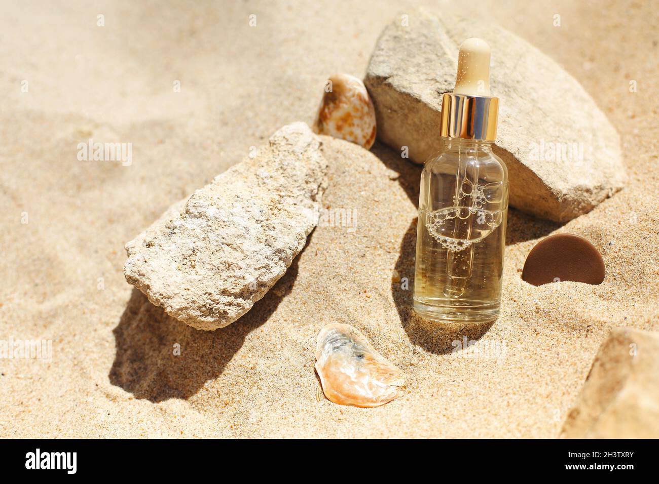 Essential oil on stones on beach Stock Photo - Alamy