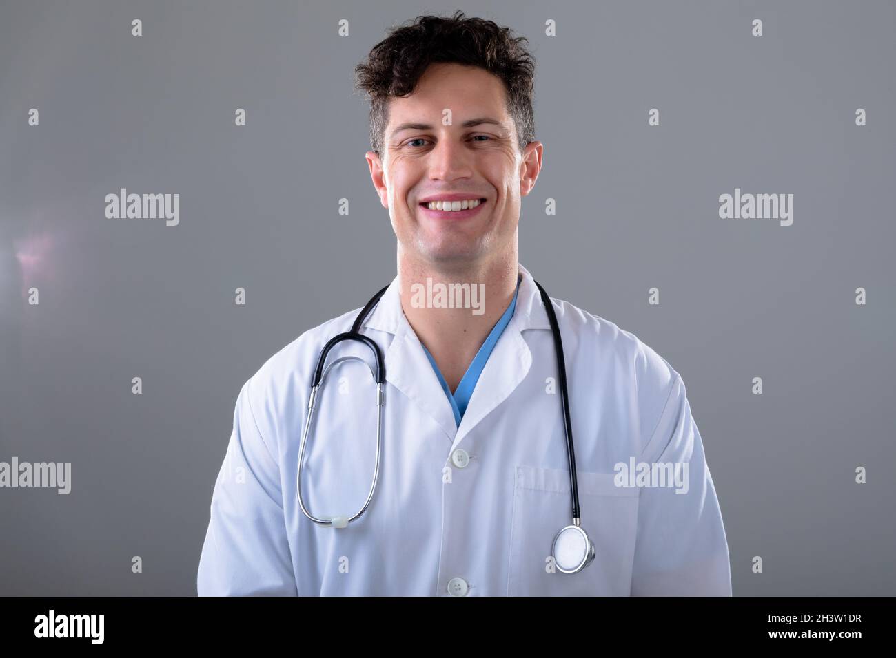 Portrait of caucasian male doctor looking at camera smiling, isolated ...