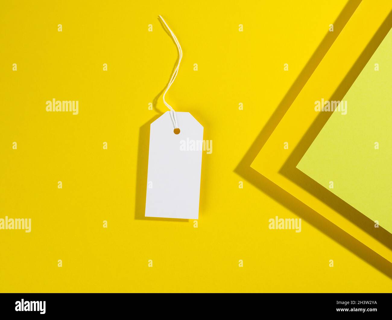 Blank rectangular paper yellow price tag with white rope on yellow ...