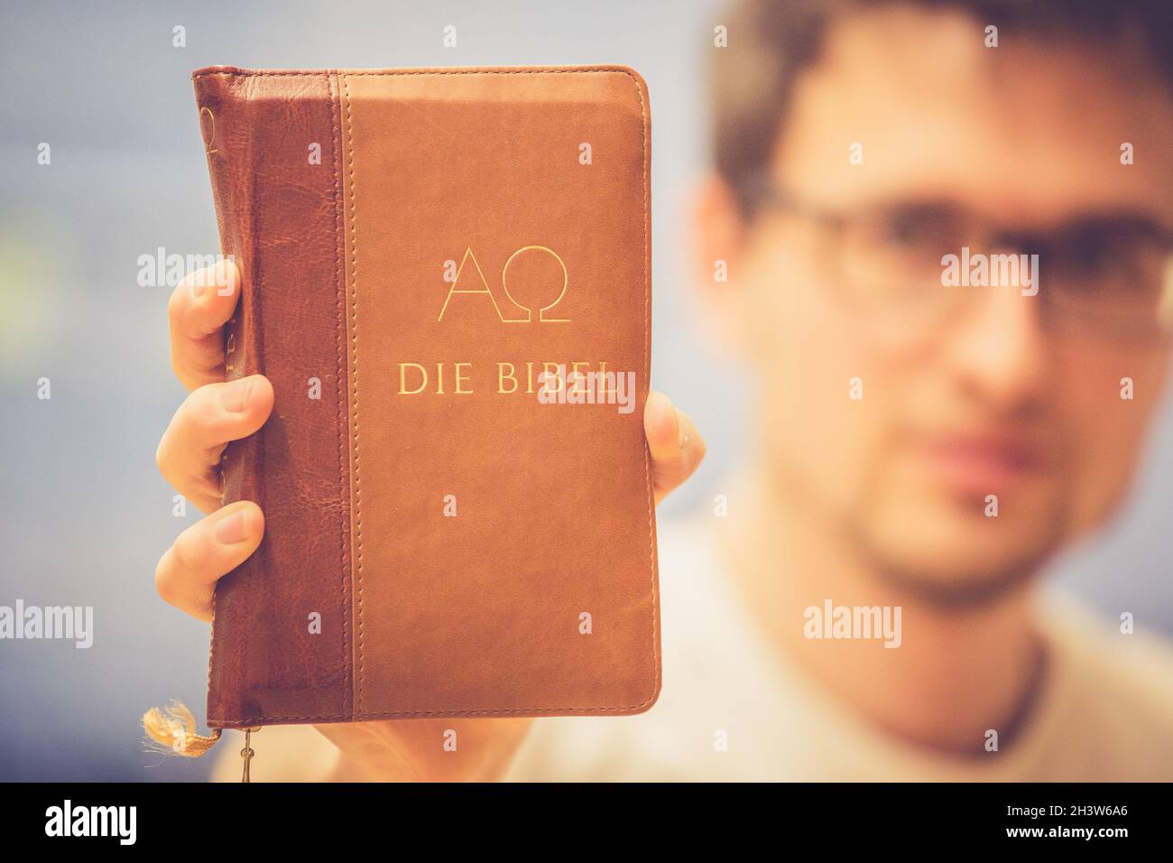 Christian preacher: Young man is holding the bible, praying Stock Photo ...