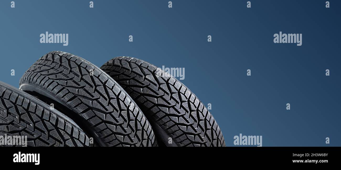 Winter car tires. Group of tires for winter driving on a blue ...