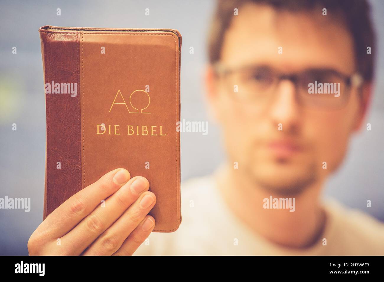 Christian preacher: Young man is holding the bible, praying Stock Photo ...