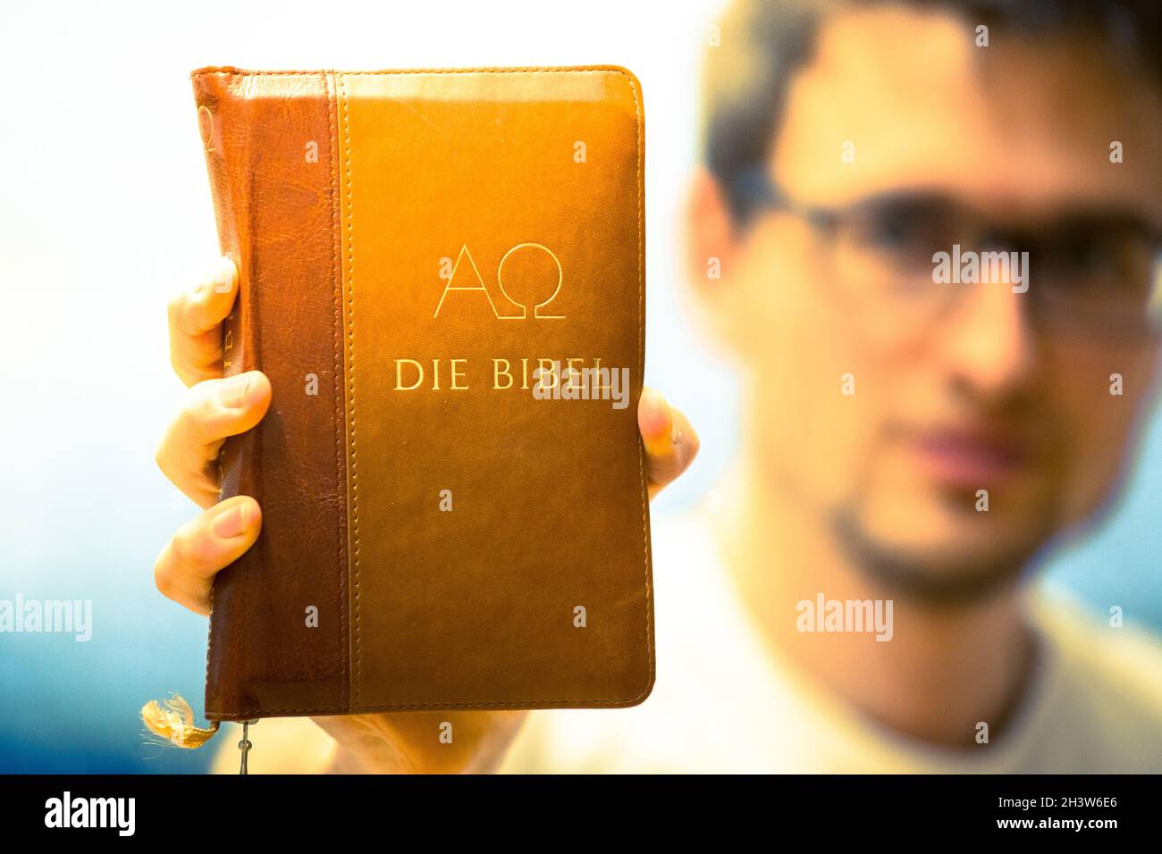 Christian preacher: Young man is holding the bible, praying Stock Photo ...
