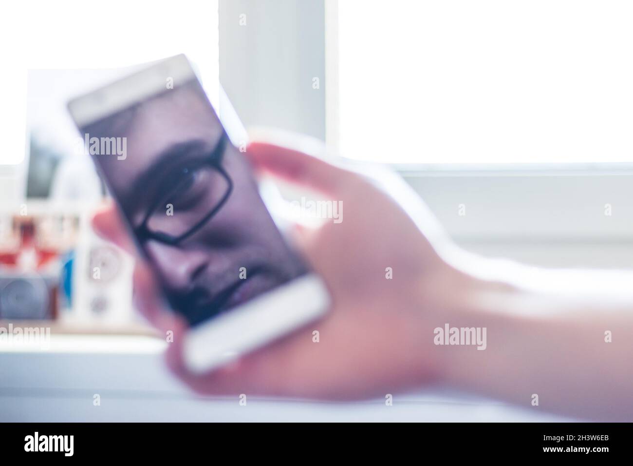 Smart phone in the hand, reflection of a face on the black display ...