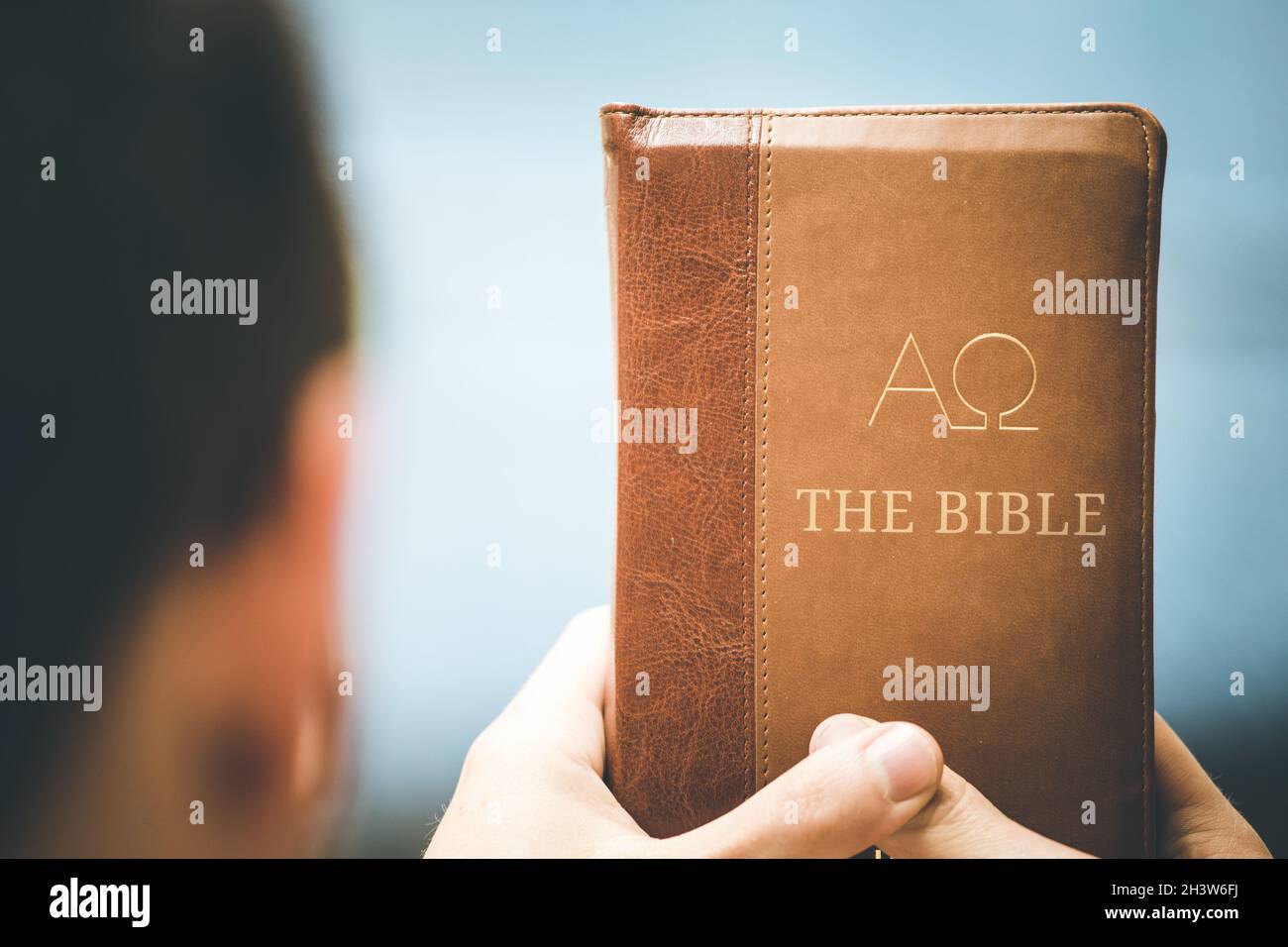 Christian preacher: Young man is holding the bible, praying Stock Photo ...