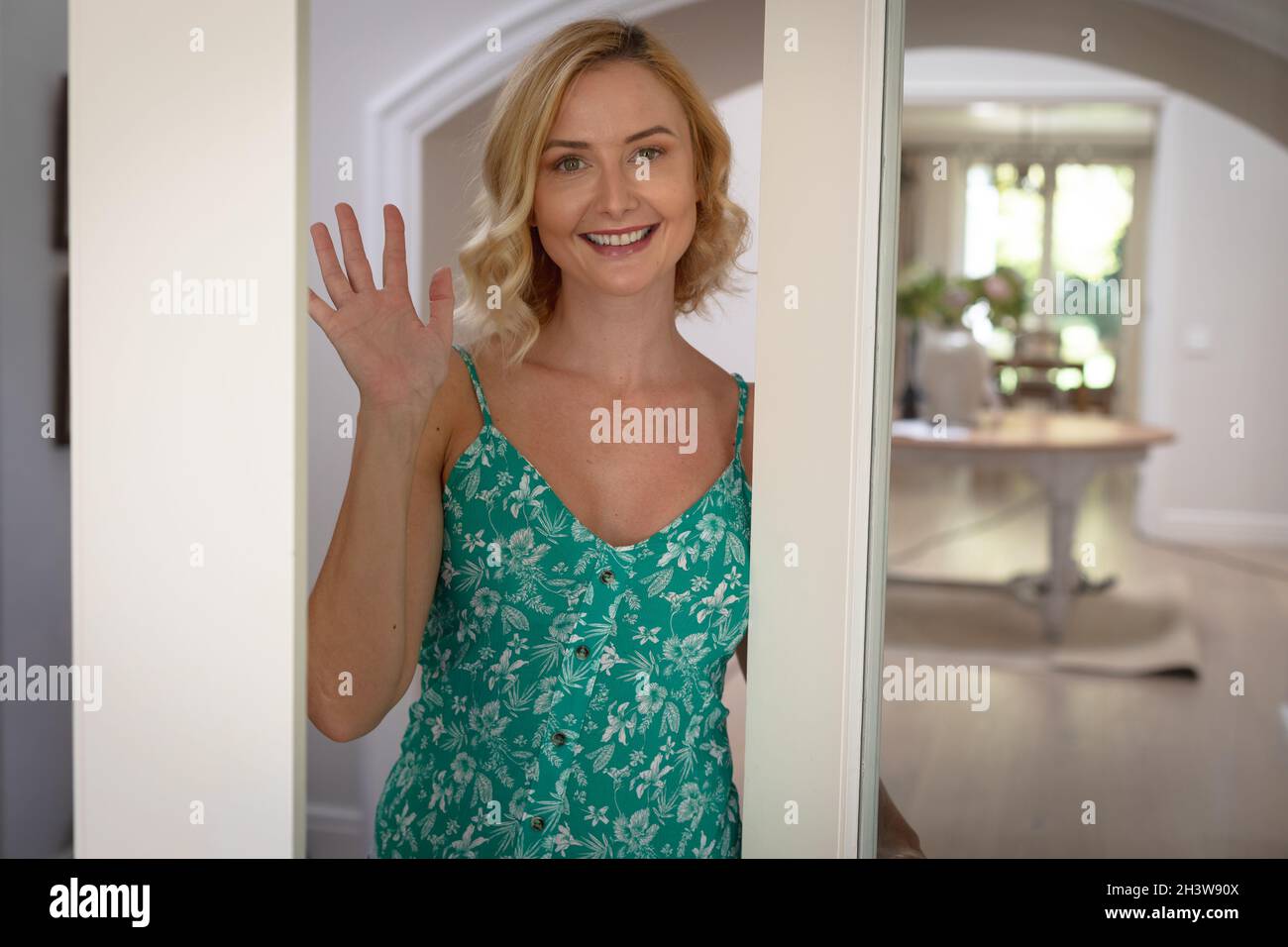 Portrait of happy caucasian woman at home, smiling and waving hand ...