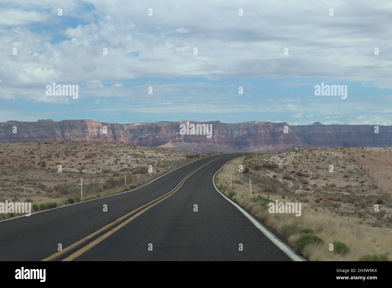 Roadway going toward a mesa among dramatic desert landscape at the ...
