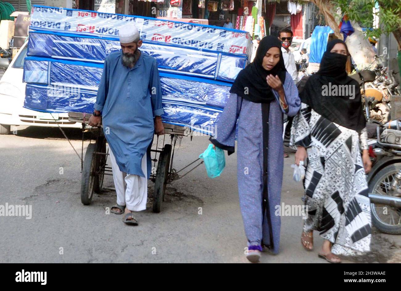 Labour carries overloaded goods at push-cart without any safety ...