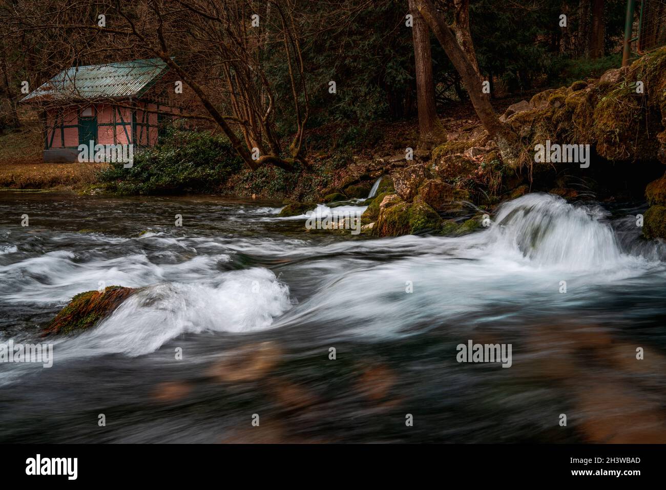 Secluded cabin in winter landscape. Water stream. Long exposure shot ...
