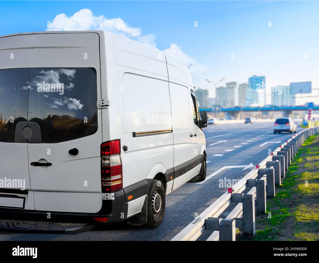 White van moving on the highway at cityscape background Stock Photo - Alamy