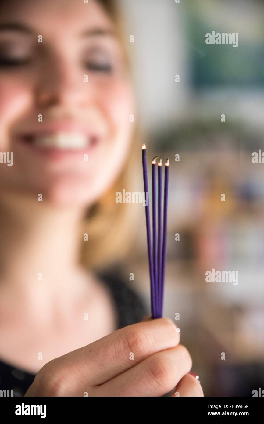 Young girl is enjoying the smell of smoking joss sticks Stock Photo - Alamy