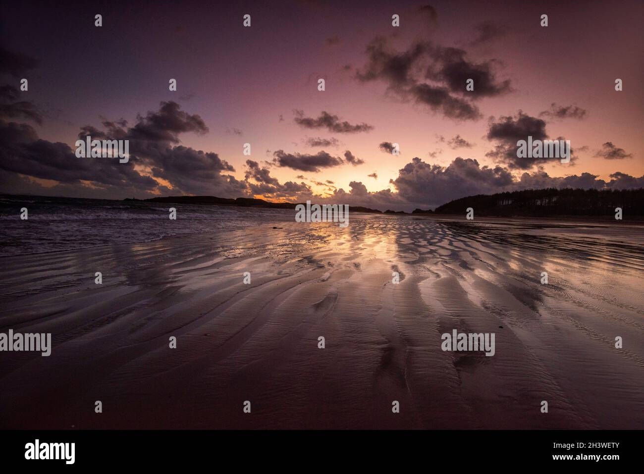 Sunset reflections at Traeth Llanddwyn, Anglesey Wales UK Stock Photo ...