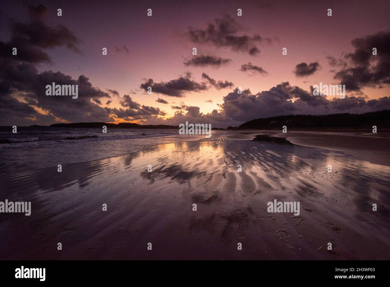 Sunset reflections at Traeth Llanddwyn, Anglesey Wales UK Stock Photo ...