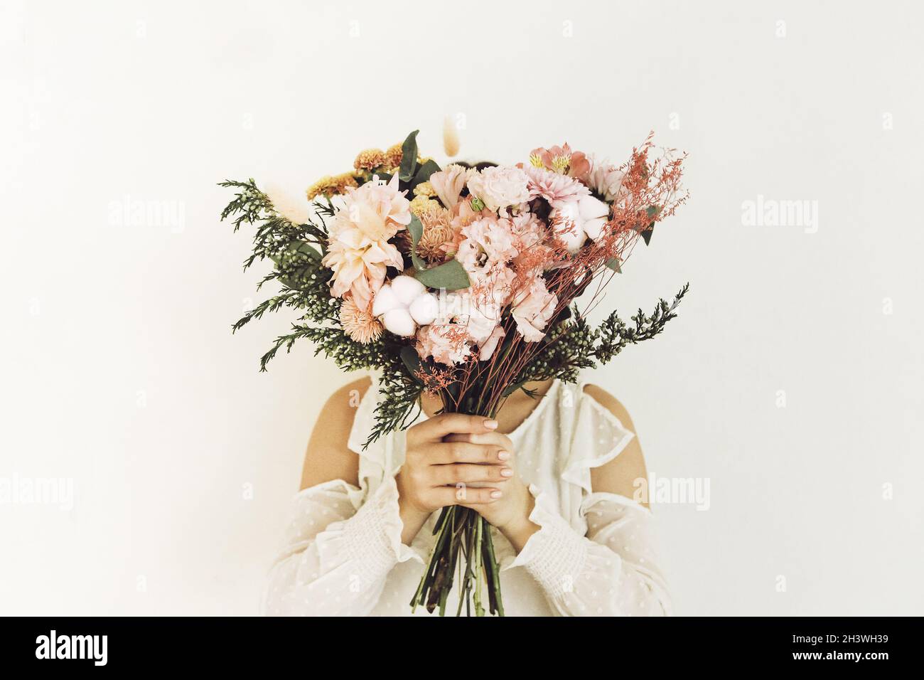 Anonymous woman hiding face behind flowers Stock Photo - Alamy
