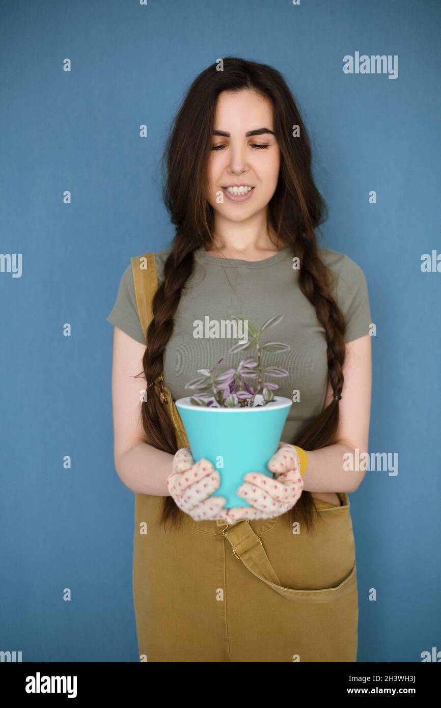 Female gardener showing potted plant Stock Photo - Alamy