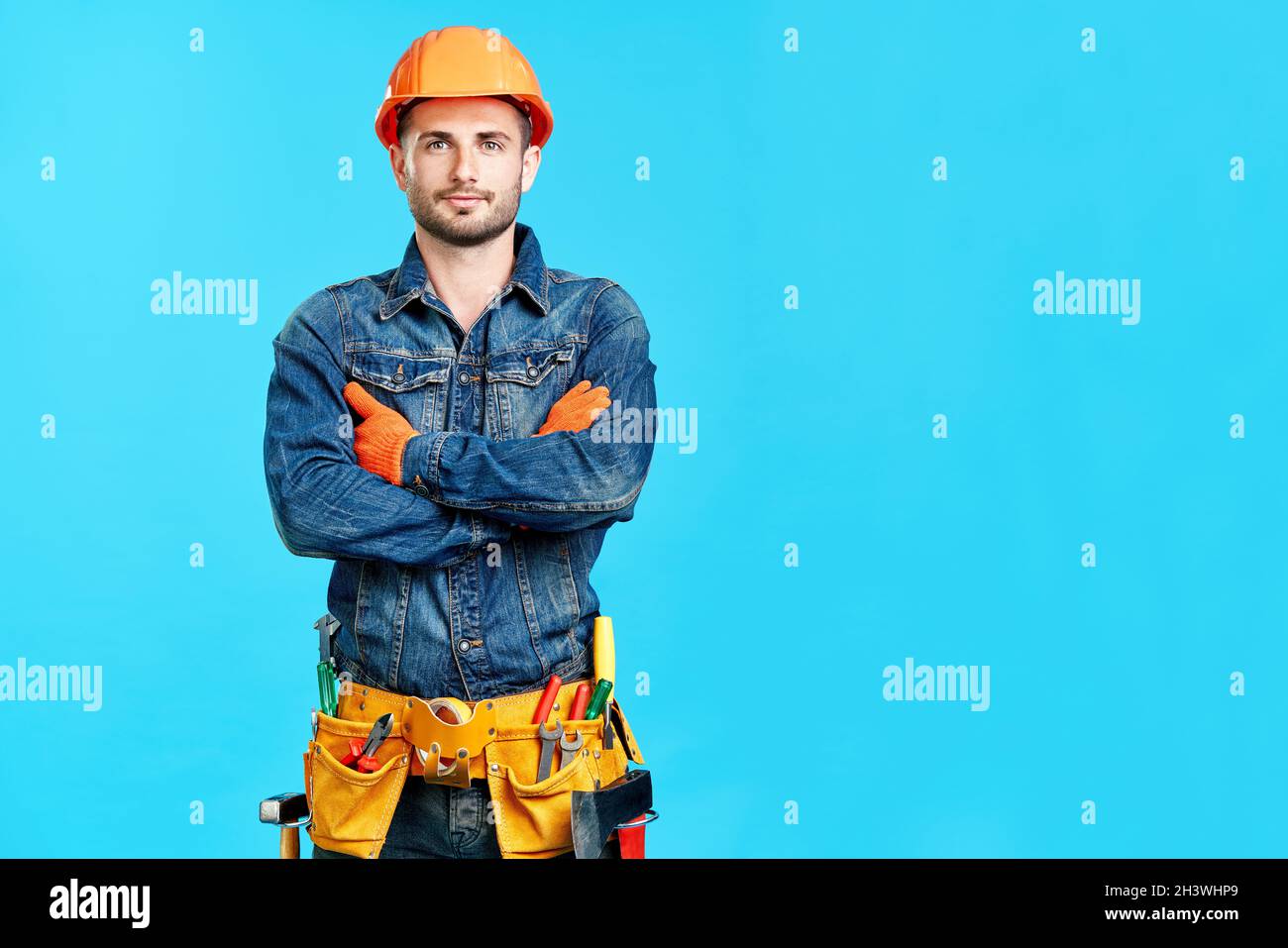 Portrait of confident handsome male construction worker with crossed ...
